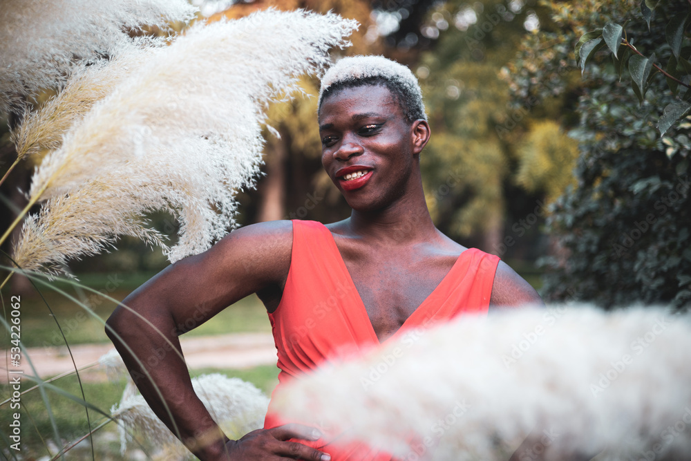 A young androgynous African boy posing in the middle of a park ...