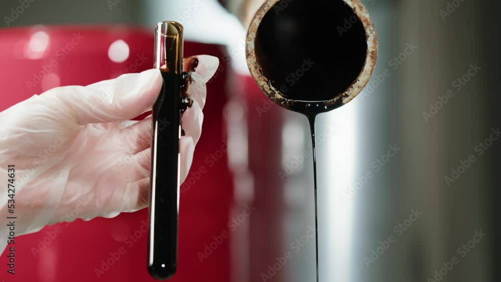 Crude black Brent oil pipeline pouring close up background with man ...