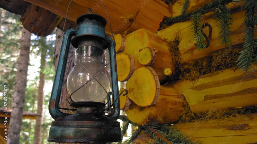 Vintage kerosene oil lantern lamp hanging on wall of house or log cabin ...