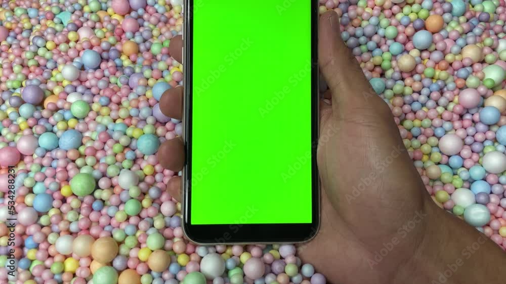 Chroma key green screen on smartphone vertical in male hand with ...