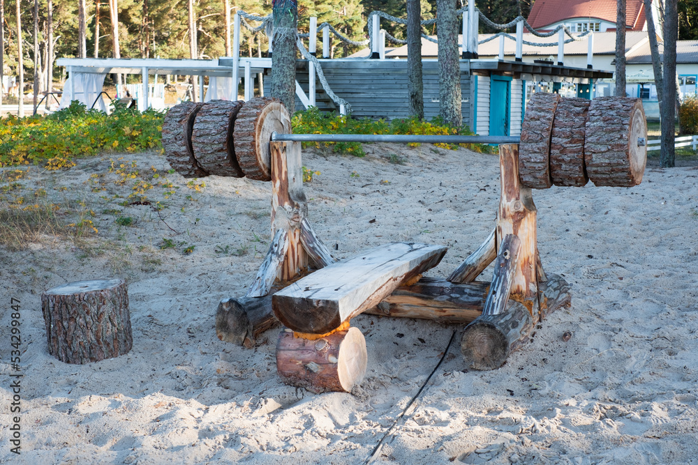 Wooden bench press equipment in a park made of heavy logs. Public ...