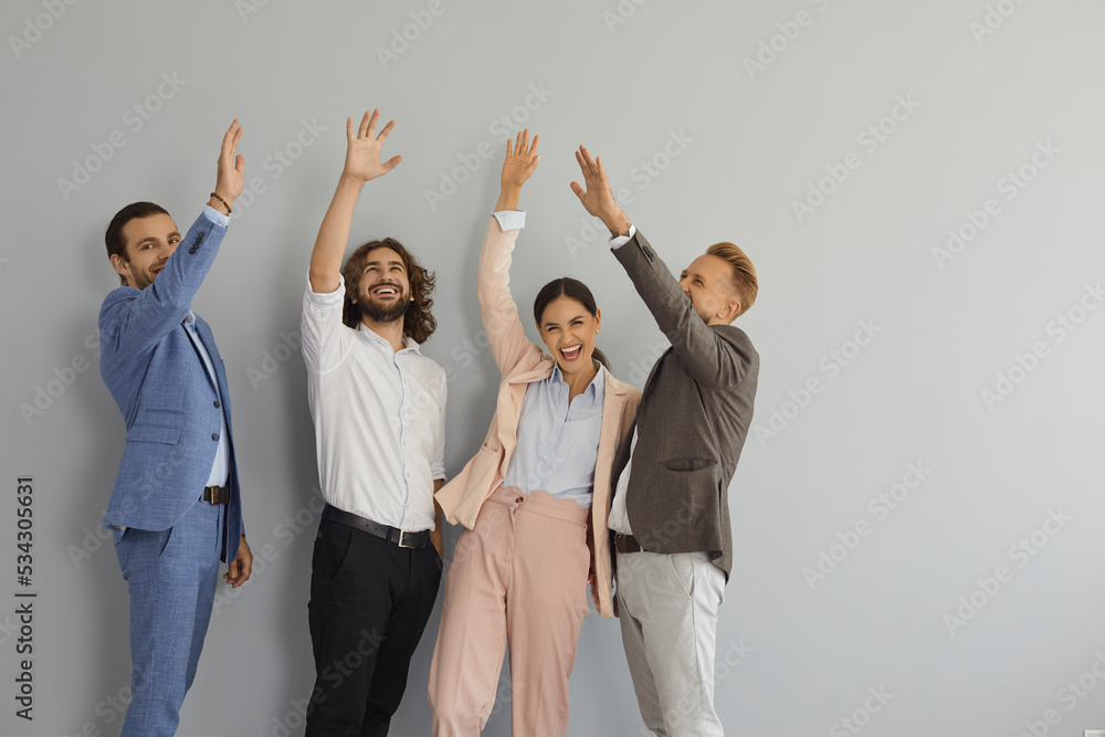 Team of happy excited people celebrating success. Group portrait of four confident coworkers ...
