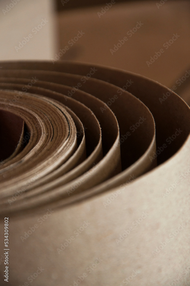 kraft paper roll. curled beige material close up. cardboard production ...