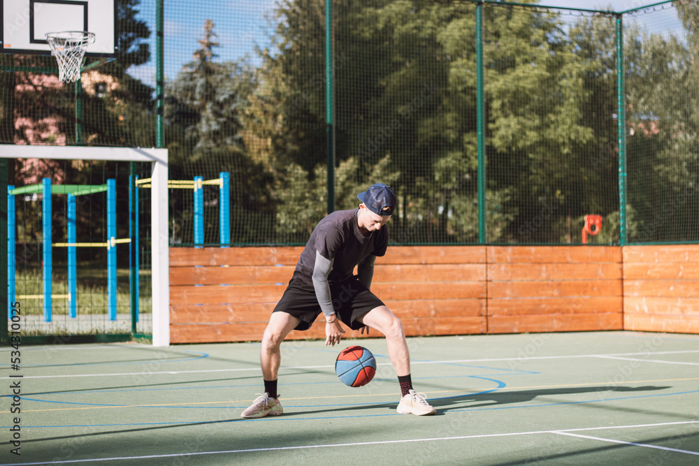 Young talent practices dribbling the basketball under his feet and ...