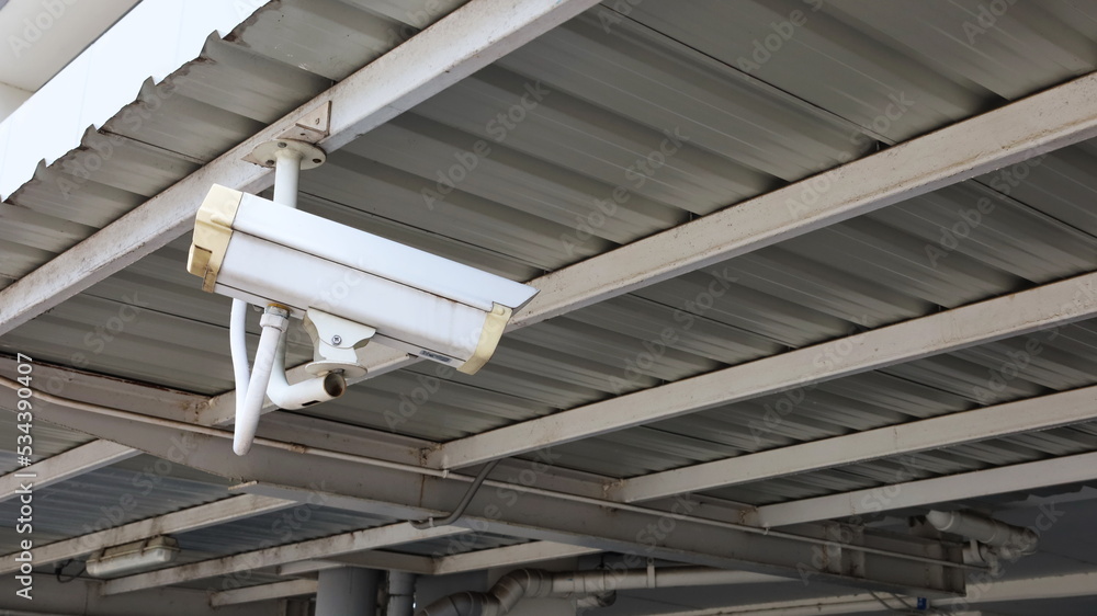 Old CCTV camera under the roof. Close up old and dirty CCTV system ...