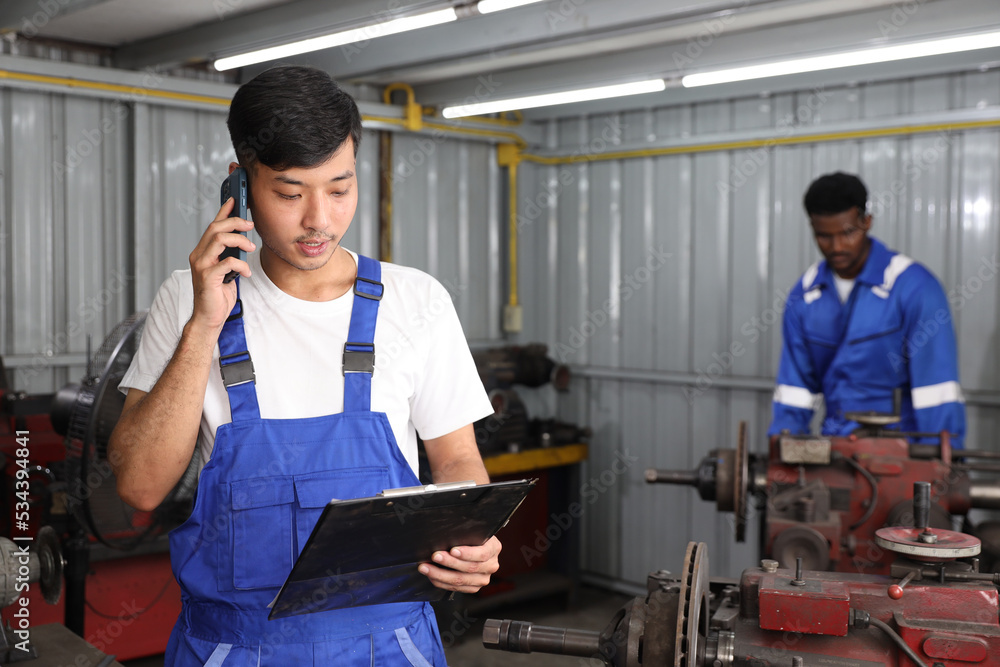 Multiethnic technician mechanic using metal lathe machine operate ...