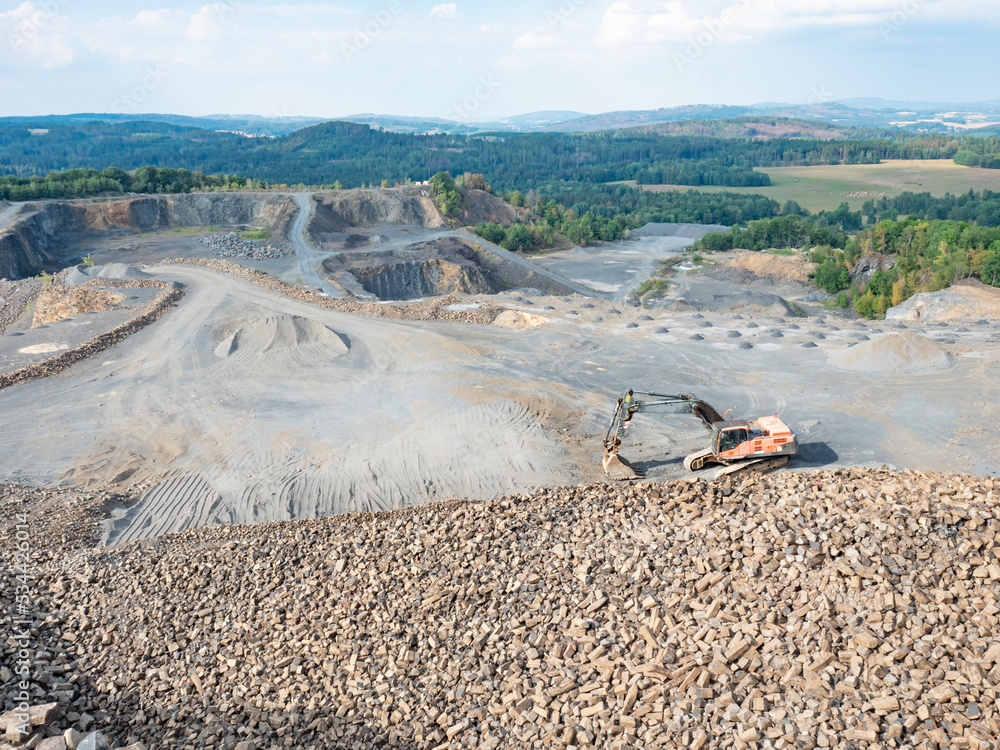 Foto de Old worn out loader between piles of crushed basalt stones. do ...