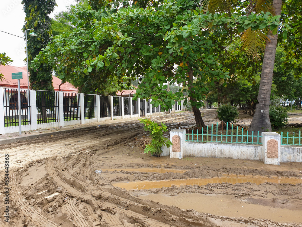 Thick, wet mud covering a main road in Dili city centre after heavy ...