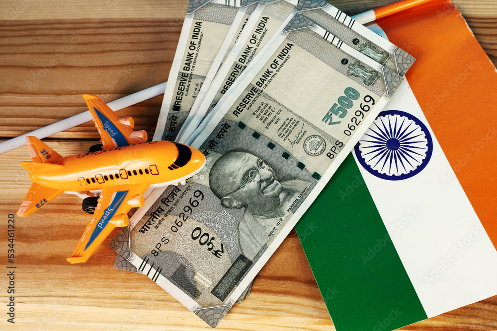 Miniature plane, rupees and Indian flag on the table. Concept of air ...