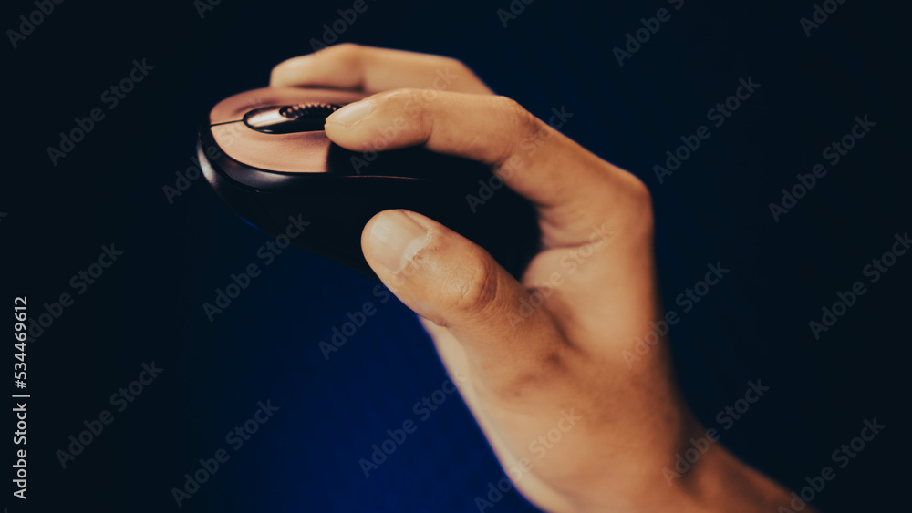 Hand using a modern ergonomic wireless computer mouse, holding and ...