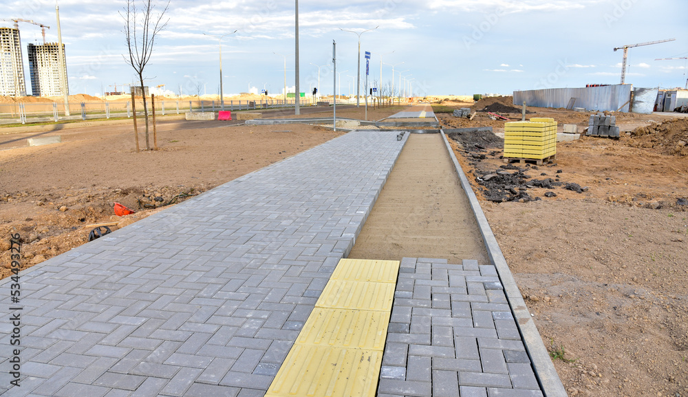Paving bricks at construction site. Laying paving slabs and borders in ...