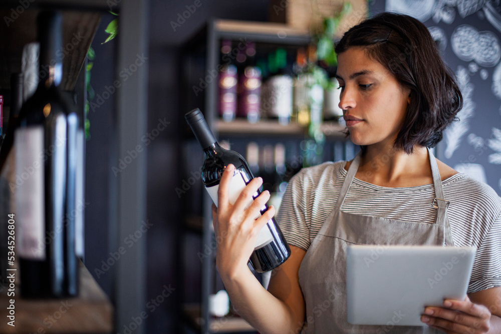 Wine store female worker reading wine bottle label Stock Photo | Adobe ...