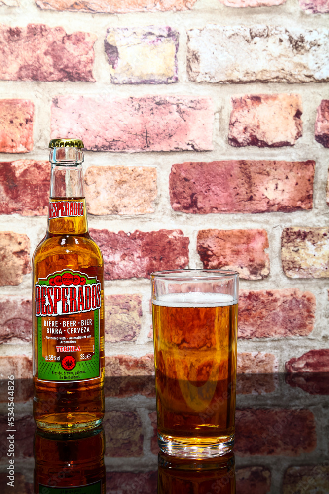 Bottle and glass of desperados tequila flavoured lager on a glass table ...