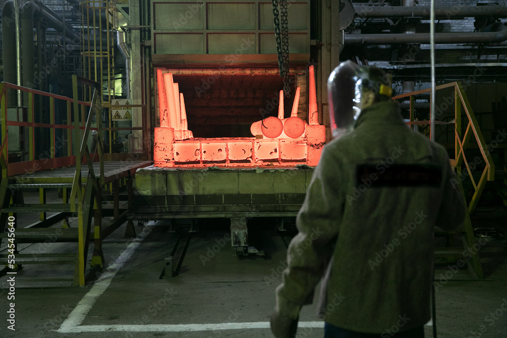 Steelworker at work. Metallurgist working at the hot furnace of a steel ...