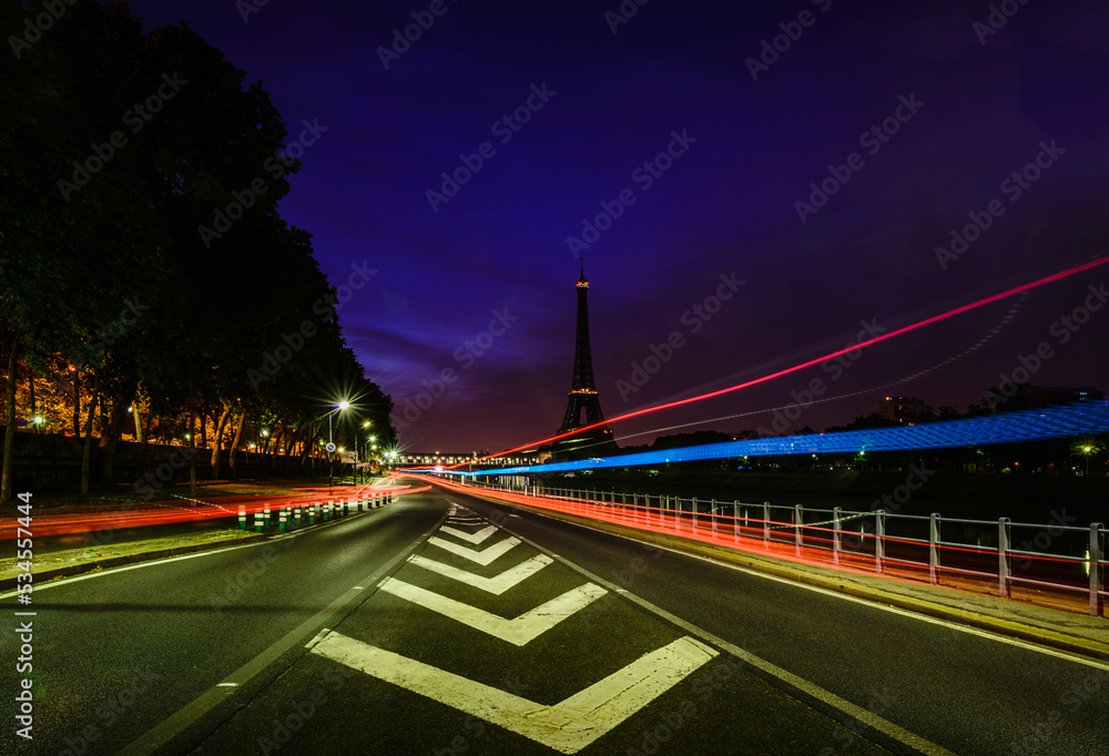 Road markings and coloured light trails at night on a straight road in ...