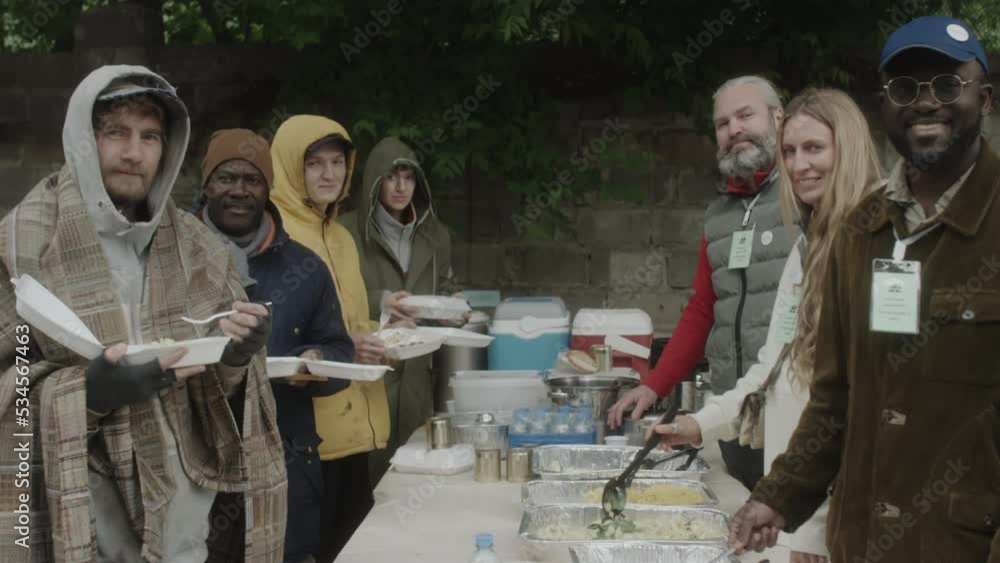 Group portrait of multiethnic homeless people and volunteers smiling ...