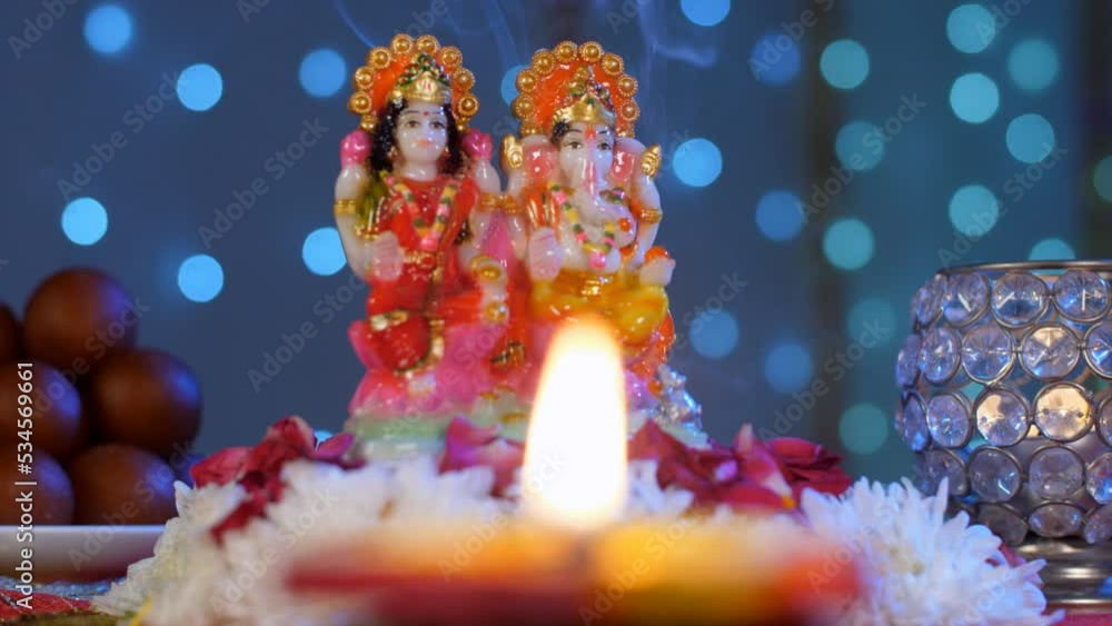 Close shot of a well-lit Diwali diyas - kept in front of Hindu god ...