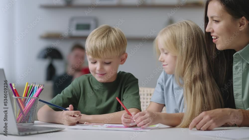 Mother or babysitter helping her children to do their homework. Cute ...