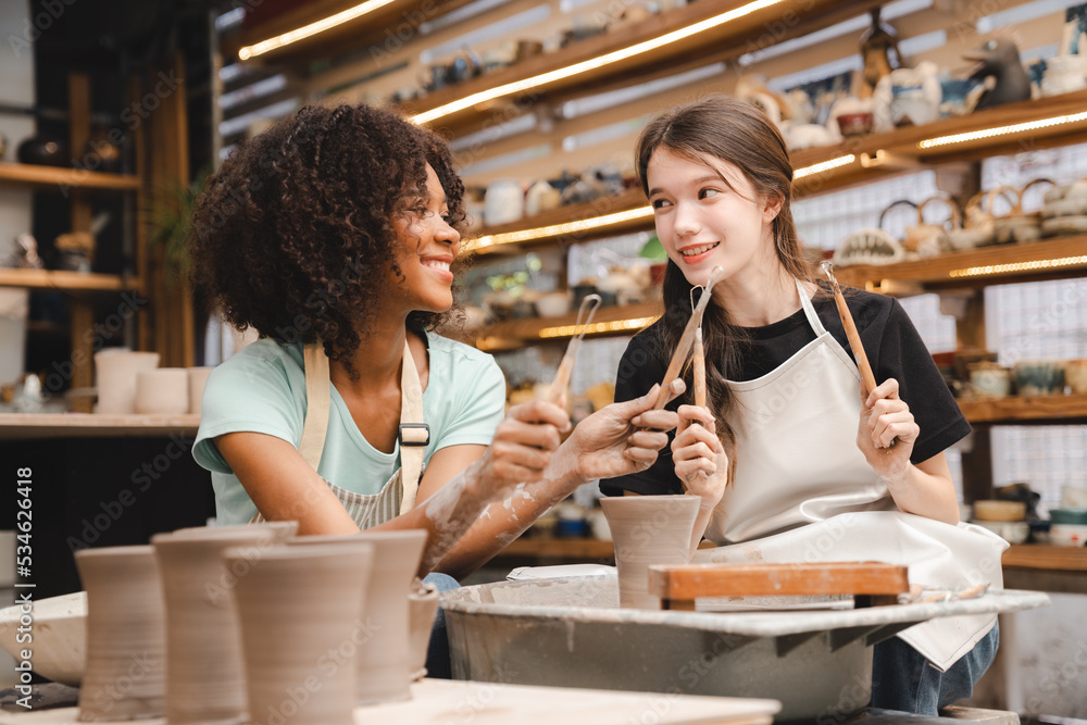 Beautiful young woman holding pottery instrument for scraping ...