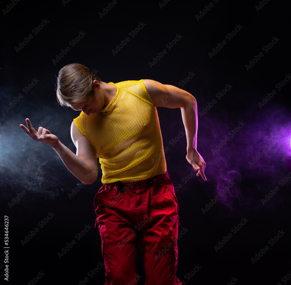 Foto de a young muscular man in a bright outfit poses in a pretentious ...