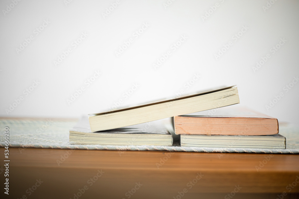 Books stack on wood desk and blurred background in the library room ...
