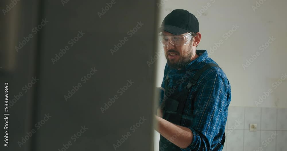 Detail view of a construction worker using a handheld demolition hammer ...