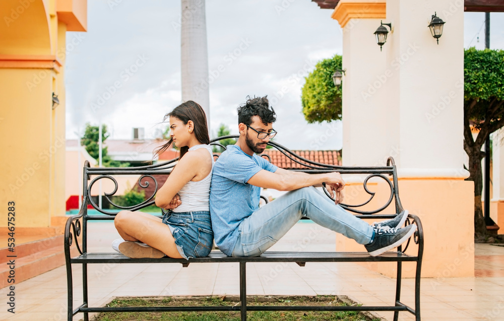 Foto de Upset couple sitting back to back on a park bench. Concept of a ...