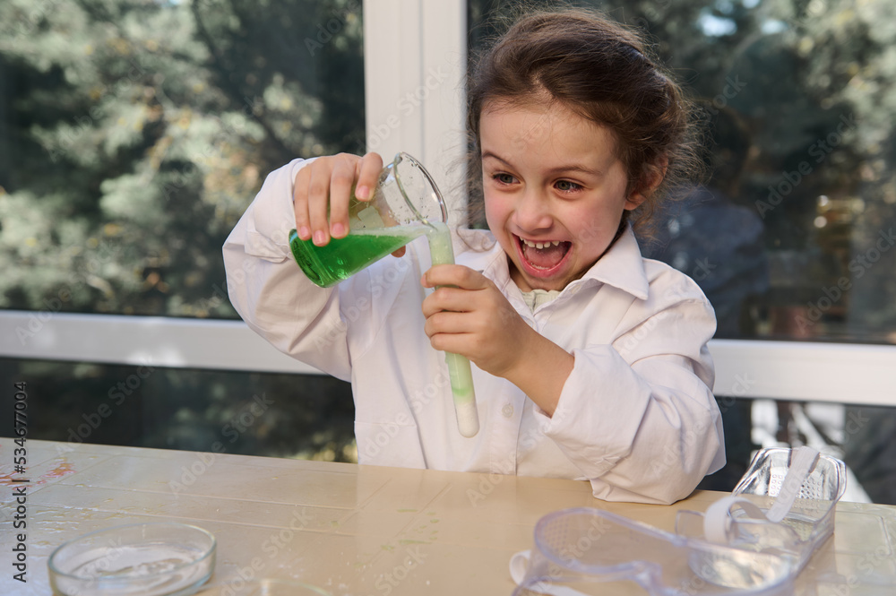 Mischievous Caucasian little girl, inspired scientist chemist wearing a ...