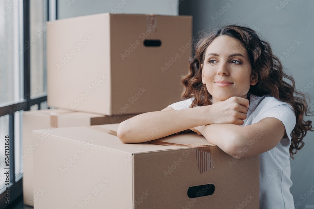 Happy female with cardboard boxes resting during packing things ...