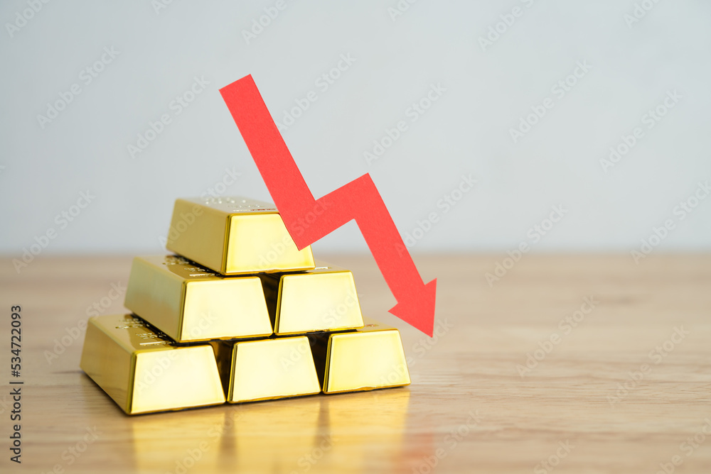 Gold bars stacks and red graph chart falling down on wooden background ...