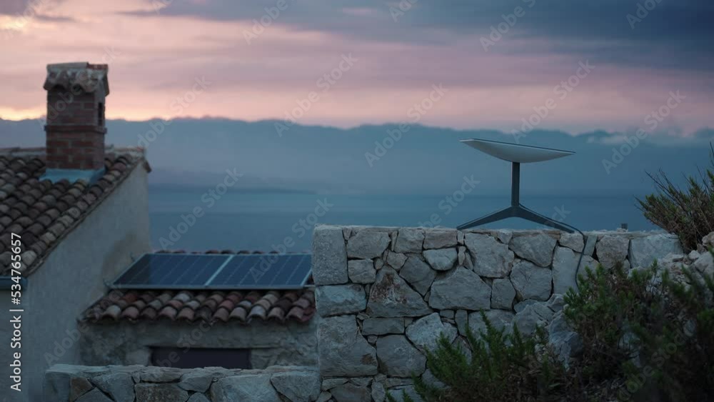 Close-up shot of Starlink satellite internet receiver dish on a fence ...