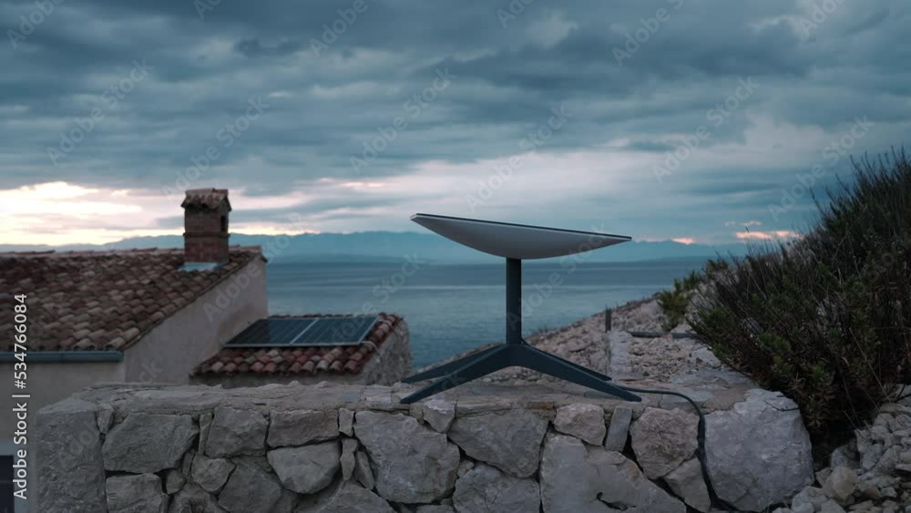 Close-up shot of Starlink satellite internet receiver on a fence of a ...
