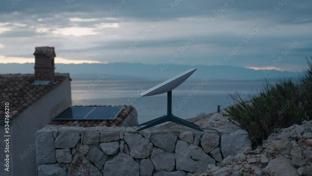 Starlink satellite internet receiver dish on a fence of a rural home on ...