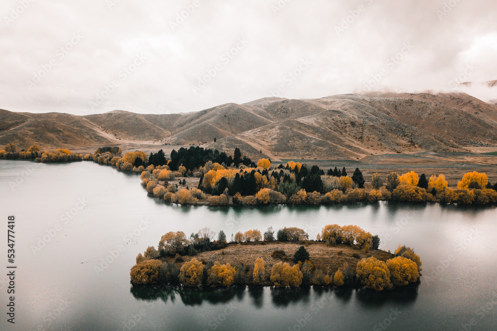 small lonely uninhabited island with different colored trees in the ...