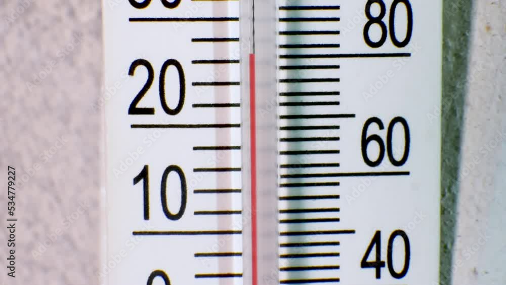 A mercury thermometer indicates a drop in outside air temperature. An ...