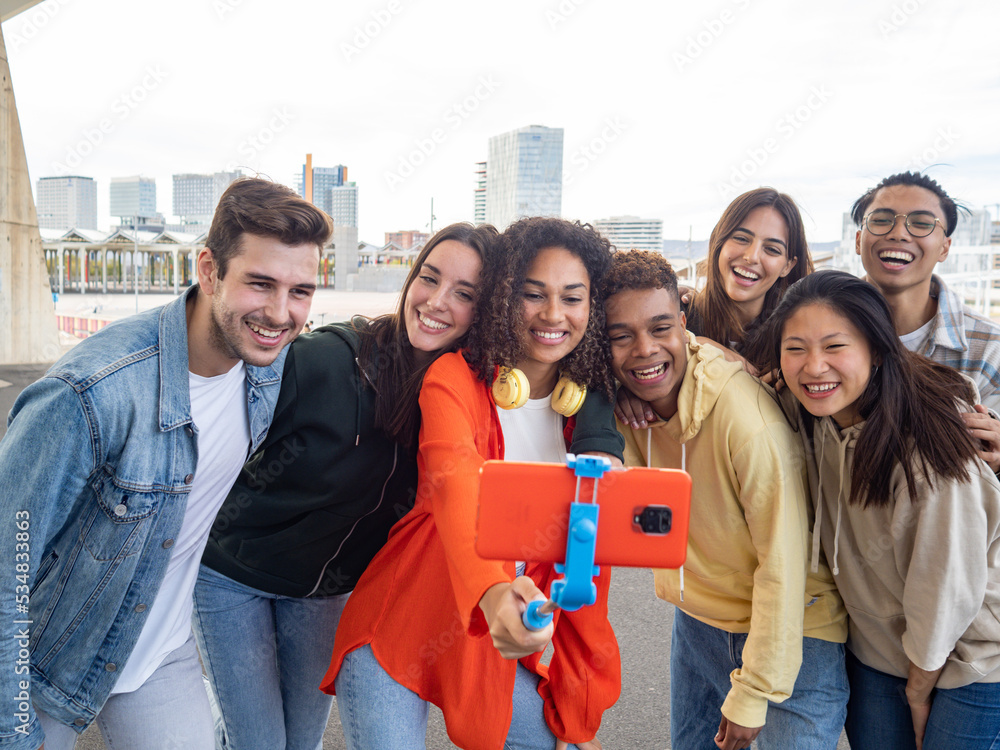Group of diverse millennials recording a video or taking a photo for ...