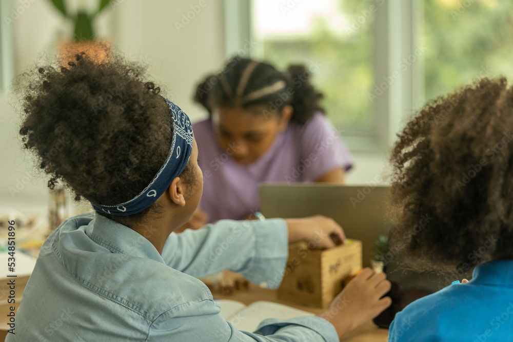 Young African girls help each other in a class. Group of young children ...
