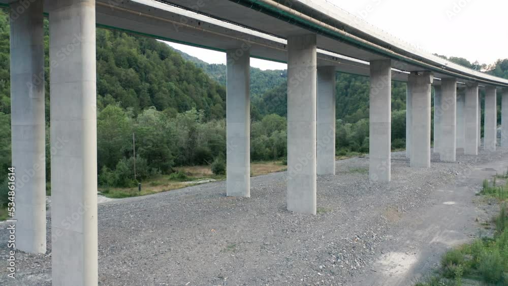 Reinforced concrete pillars supporting a bridge on a highway. Columns ...