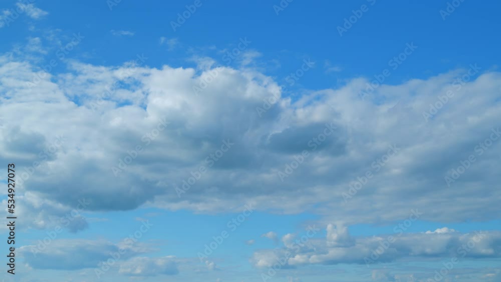 Clouds formation running across the blue sky. White puffy and fluffy ...