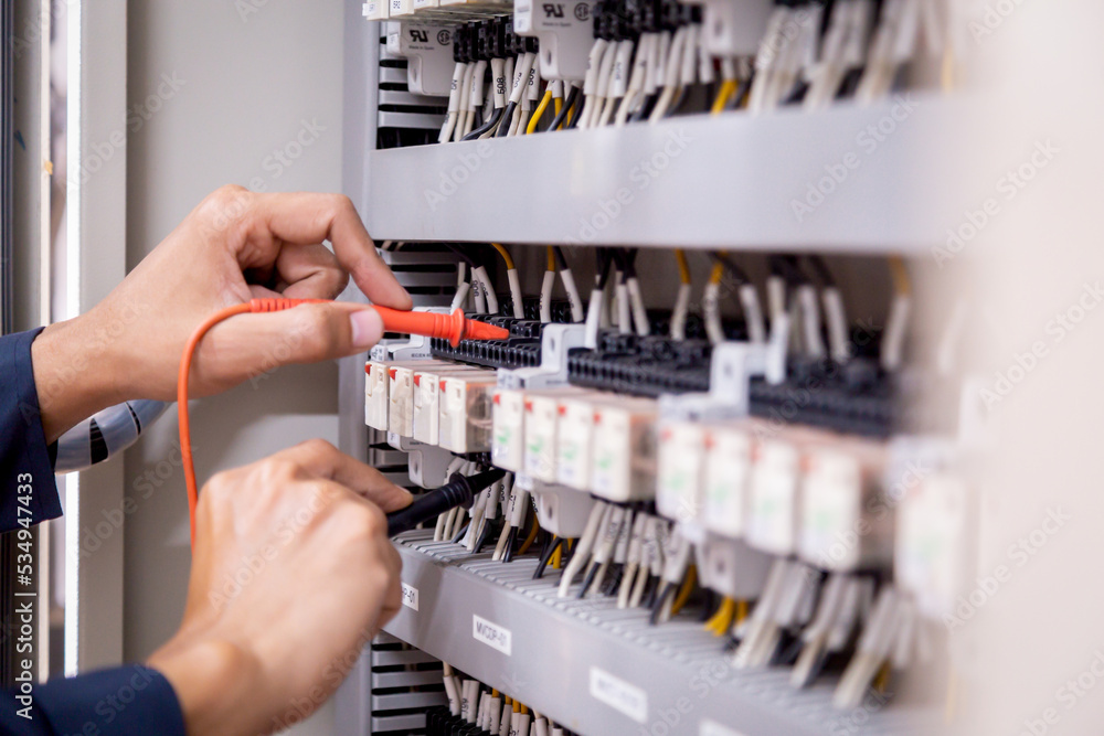 Electrical engineer using measuring equipment to checking electric ...