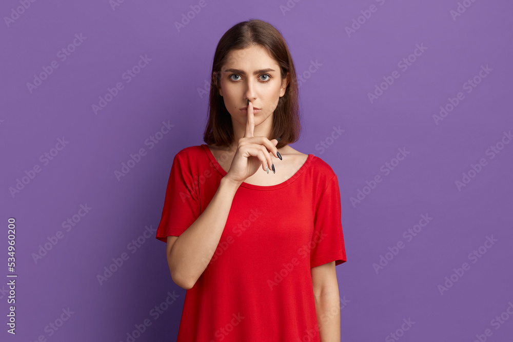 Tss, be quiet, please. Angry young pretty brunette girl in red t-shirt ...
