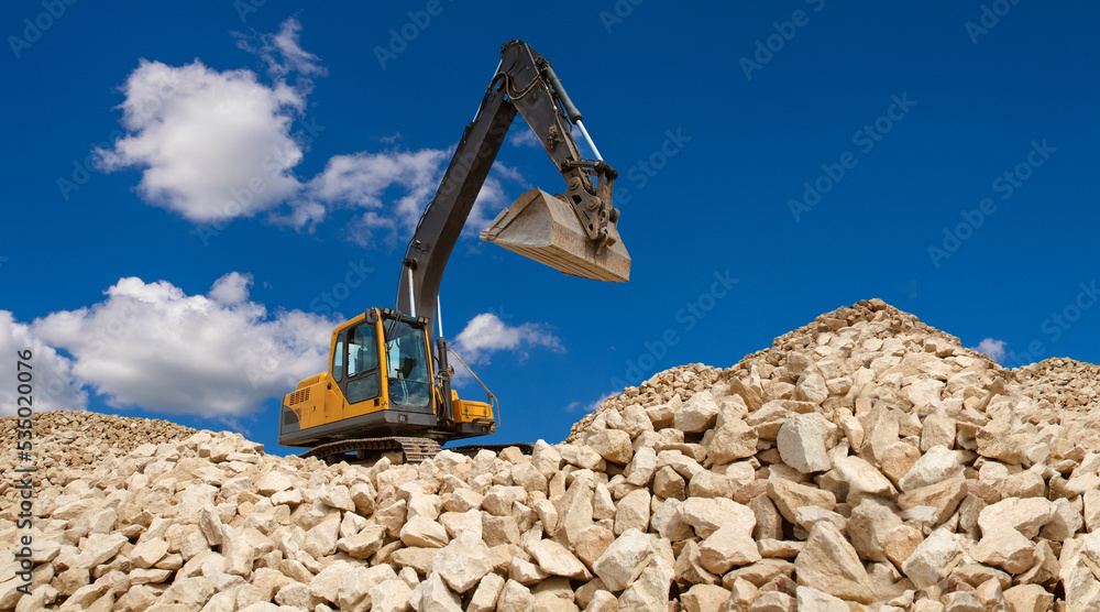 Stone mining. Excavator among small stones. Development of stone quarry ...
