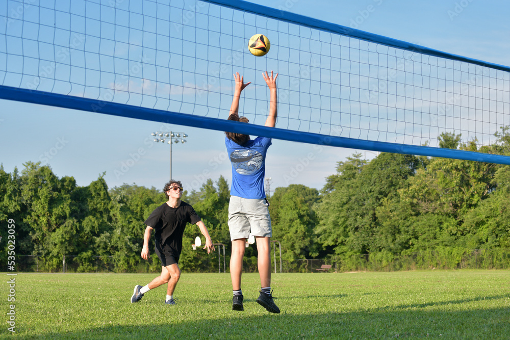 Volleyball player setting his partner in a doubles grass game Stock ...