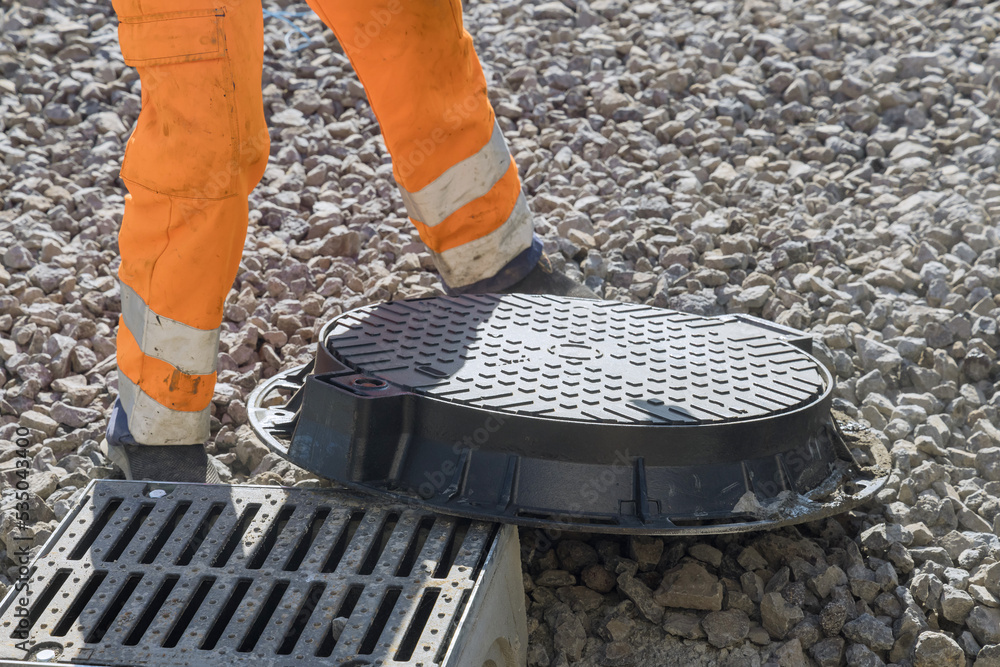 Installing cast iron sewer hatch on concrete base of installation of ...