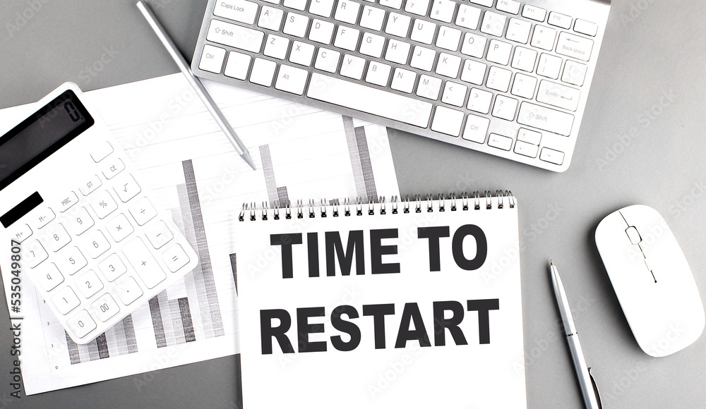TIME TO RESTART text written on notebook on grey background with chart ...