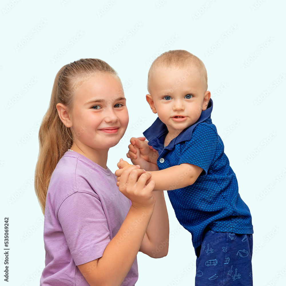 A teenage girl holds the hands of her little brother. Brother and ...