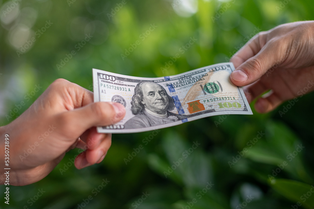 100 dollar bill passing from hand to hand Stock Photo | Adobe Stock