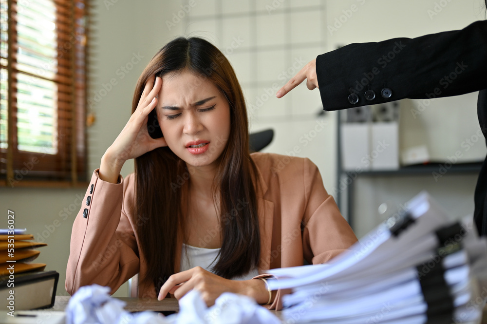 Stressed Asian female office worker gets a work complaint from her boss ...