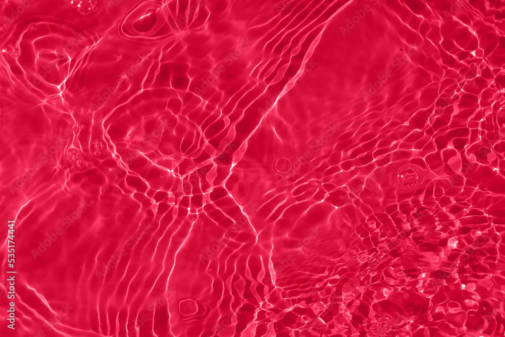 Defocus blurred transparent red colored clear calm water surface ...
