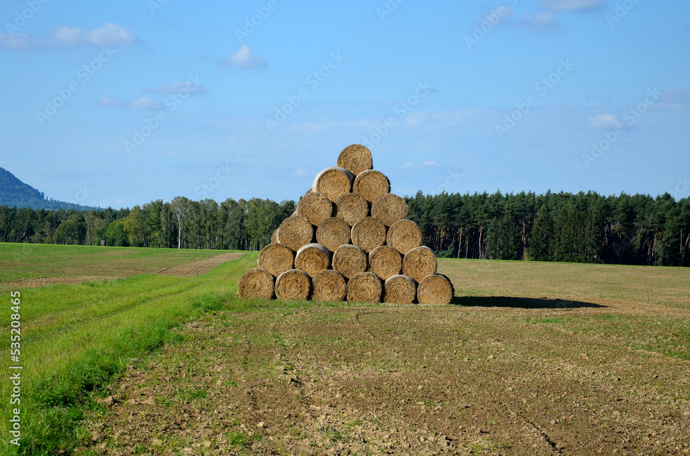 a large roll of baled straw is stacked in a pyramid. warn friends not ...